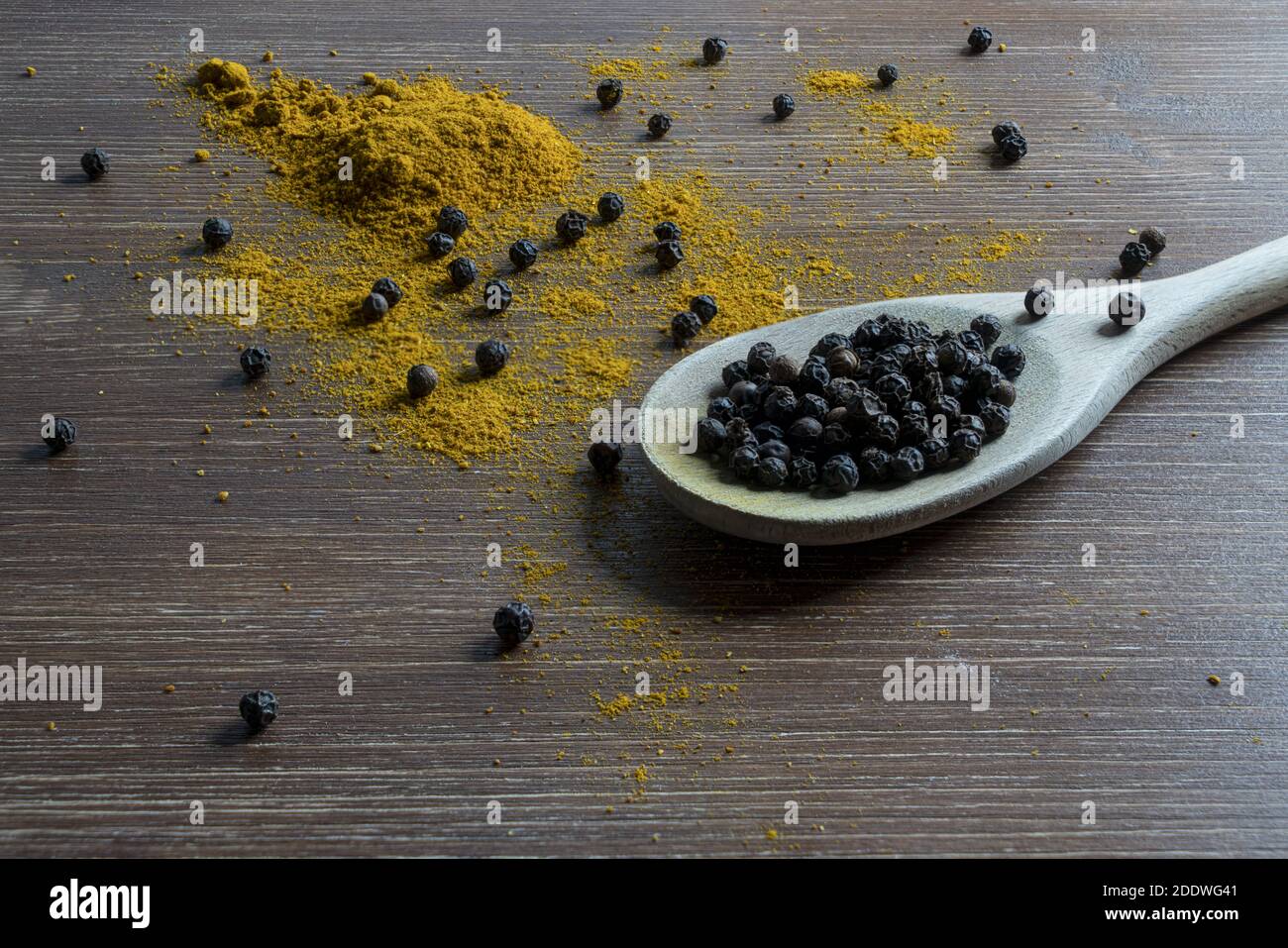 a wooden ladle with curry powder and pepper grain Stock Photo - Alamy
