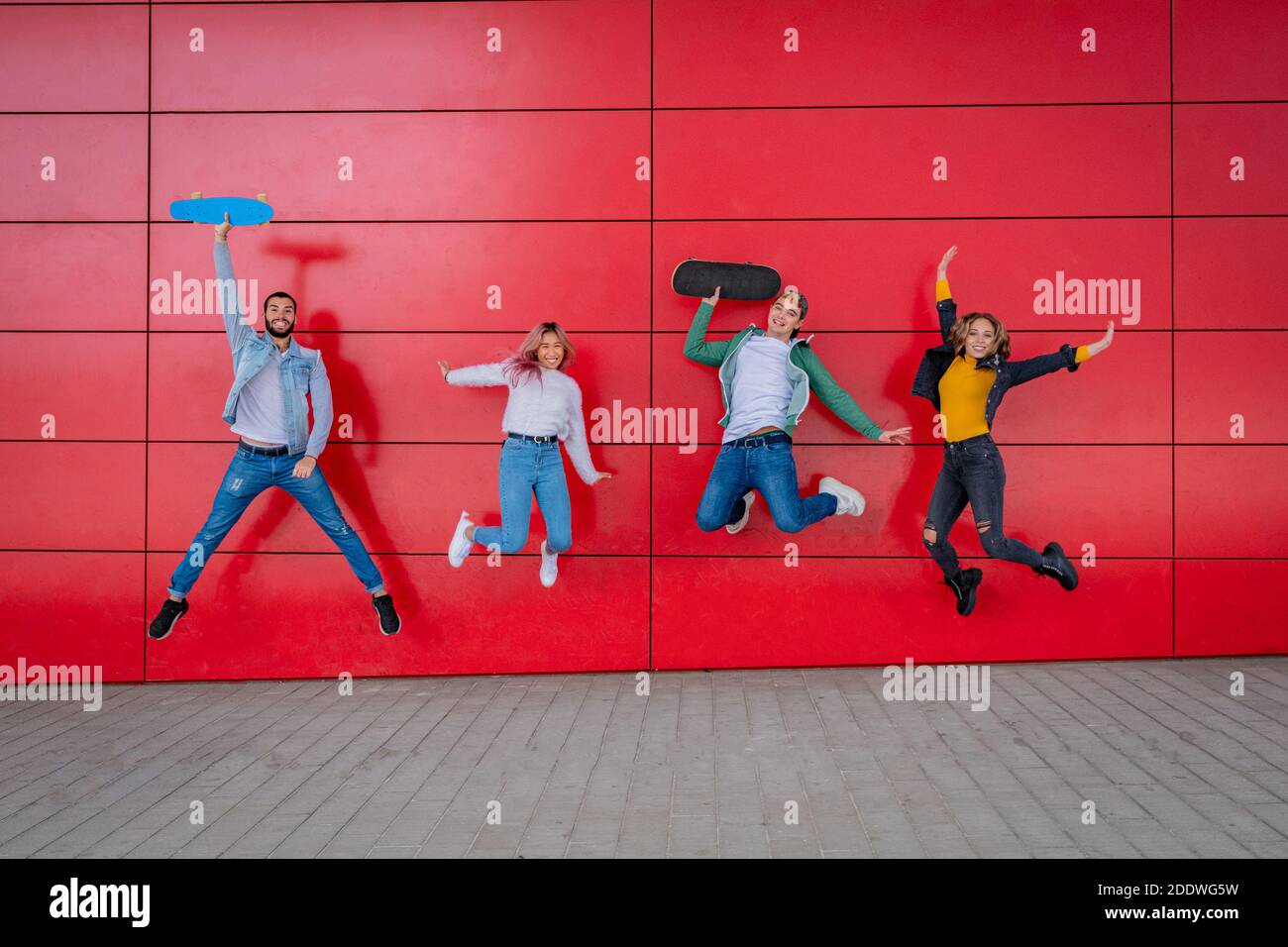 Group of happy teenagers jumping together front the wall - Friends ...