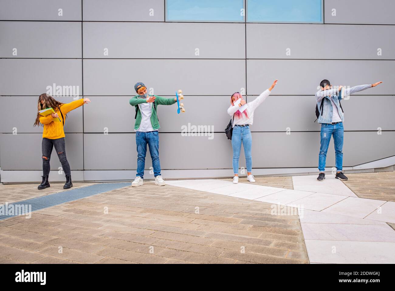 Multiethnic people dancing the dab dance keeping social distance during ...