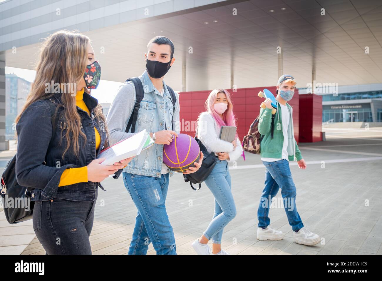 Multiracial students with face mask walking speaking wearing protective ...