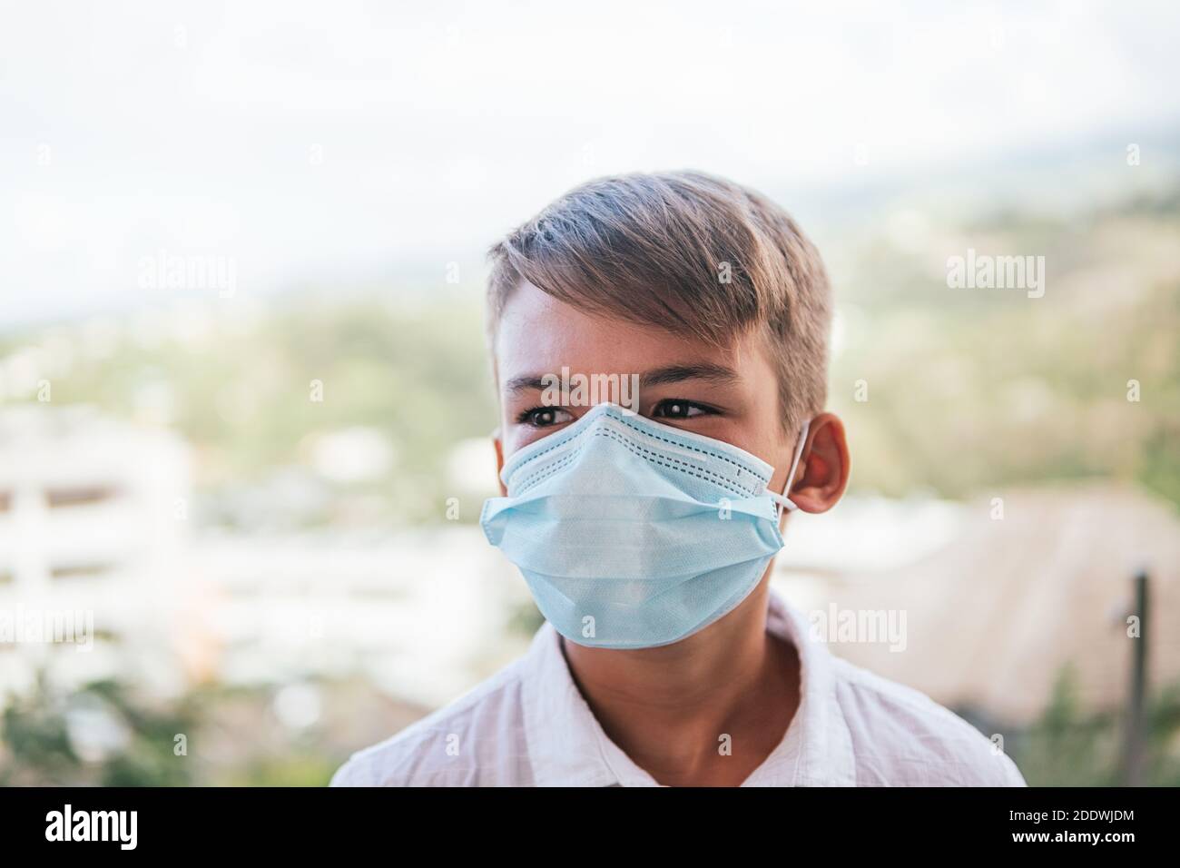 Stock photo of cute boy wearing disposable face mask due to covid19 ...