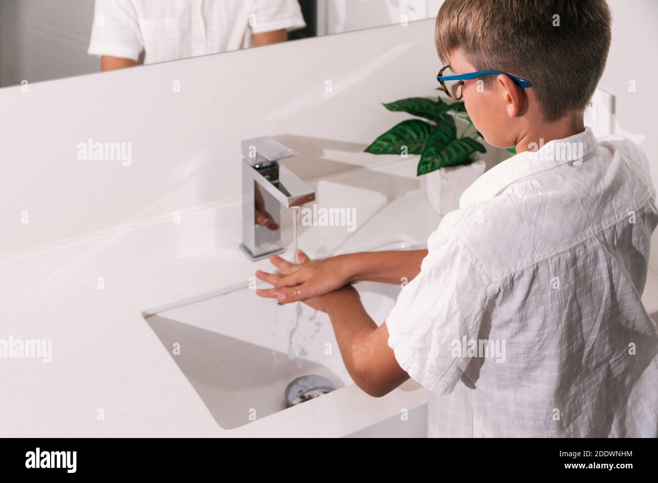 Stock photo of cute boy using soap and water to clean his hands in the ...