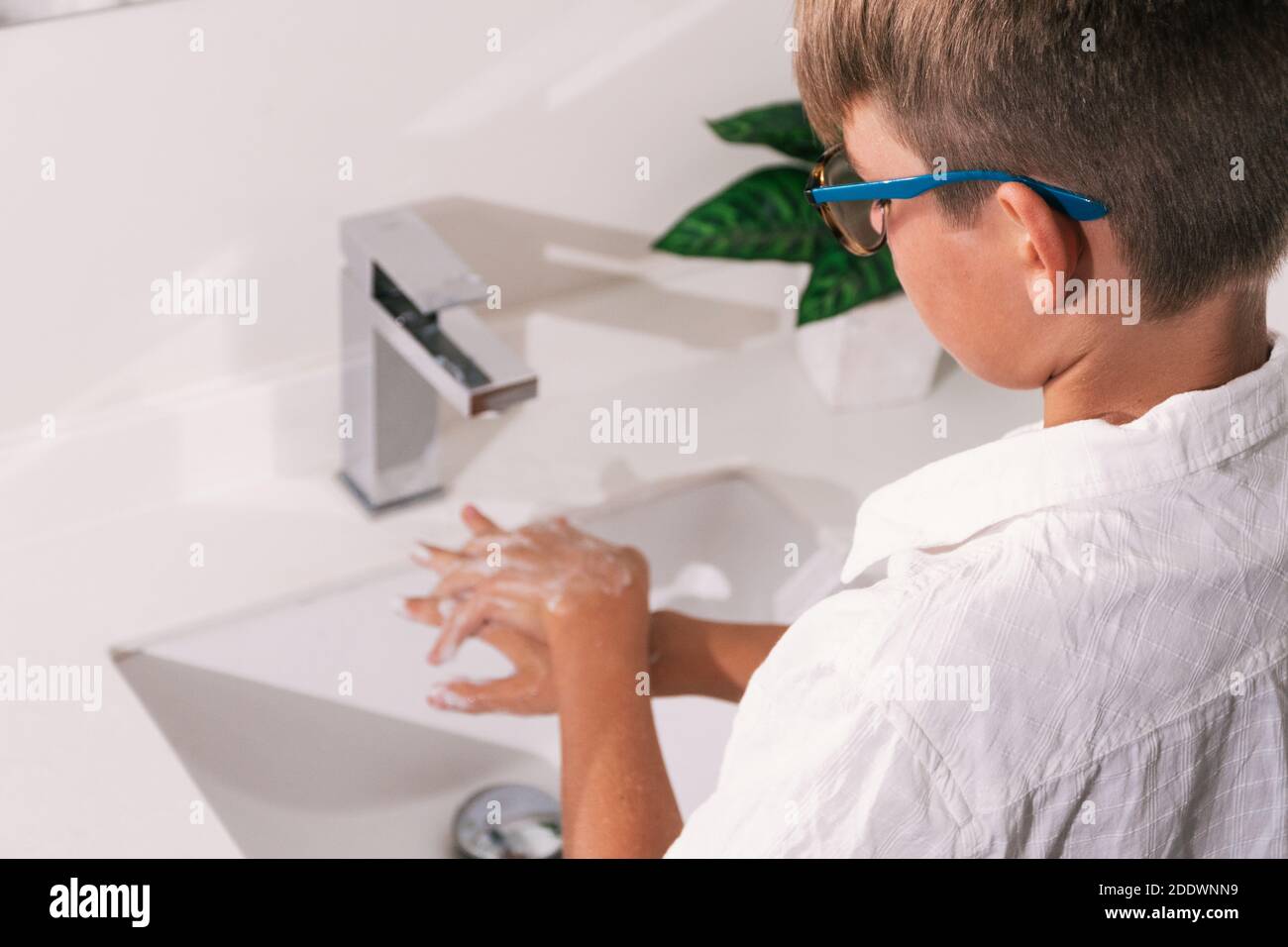 Stock photo of cute boy using soap and water to clean his hands in the ...