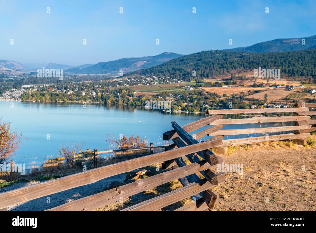 The view from behind a wooden, log fence of the lake and hills covered ...