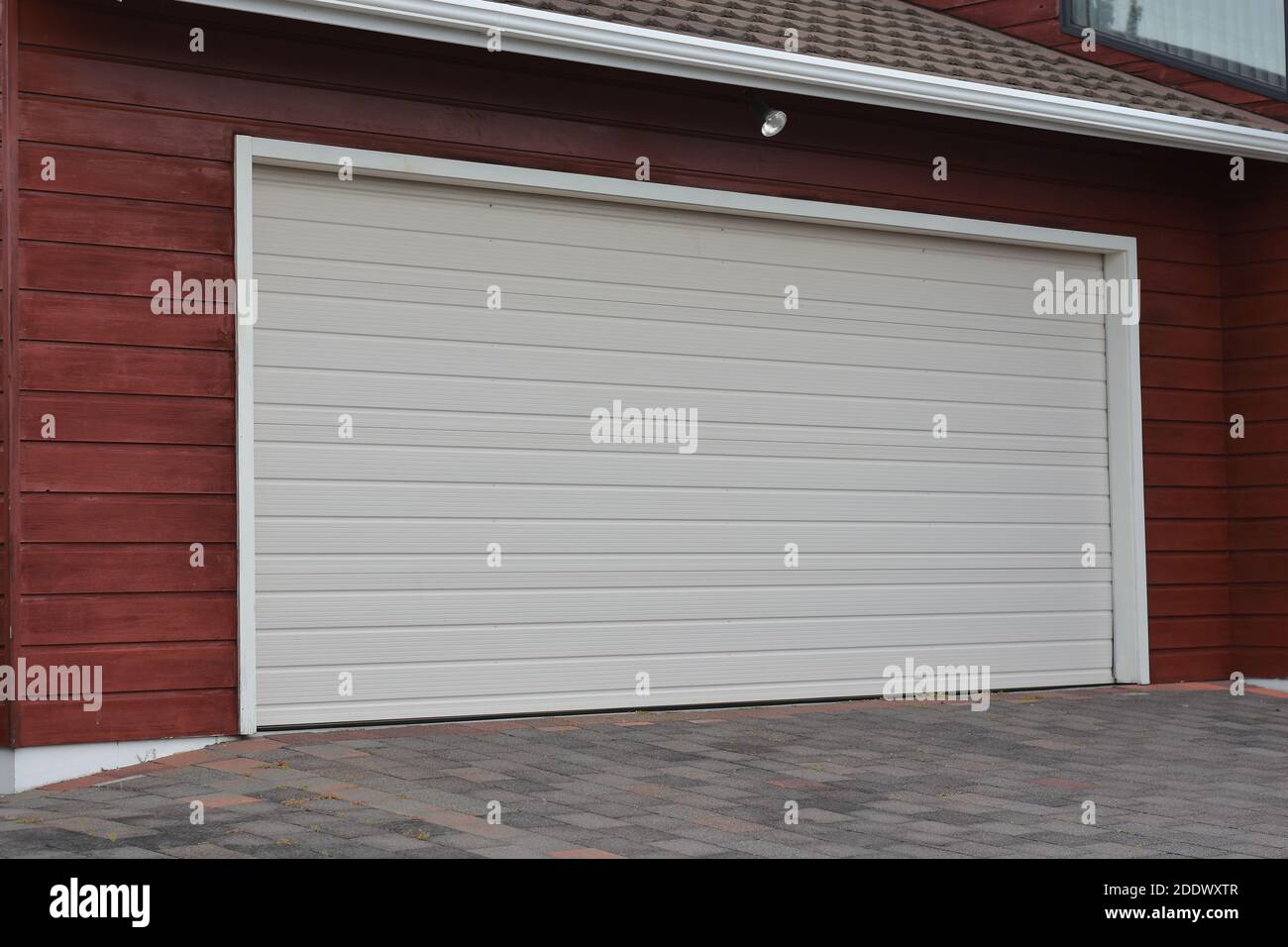 A white horizontal garage gate on a red wooden wall Stock Photo - Alamy