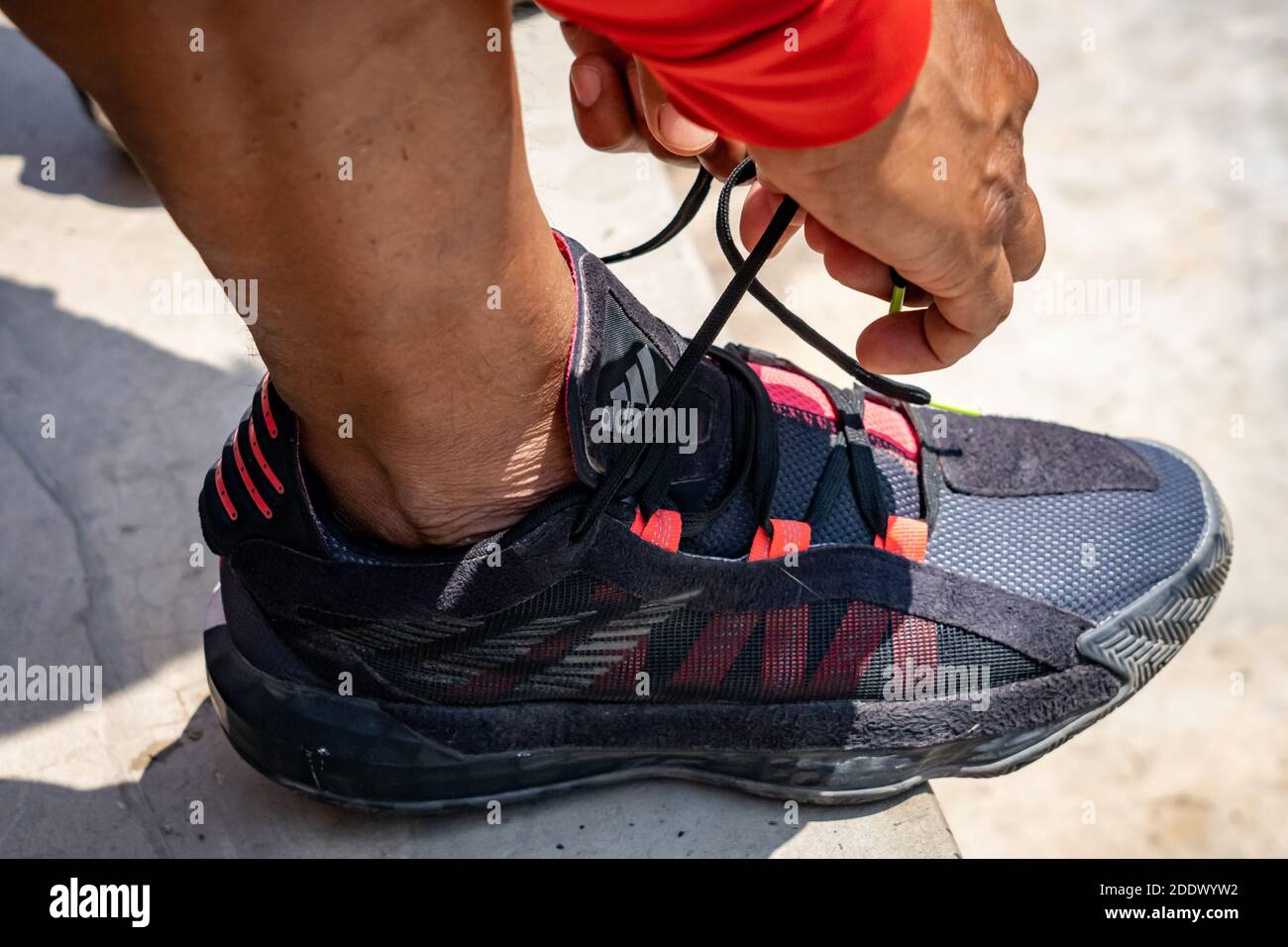 Local Sunday soccer player pauses to tie shoe in a neighborhood of Lima ...
