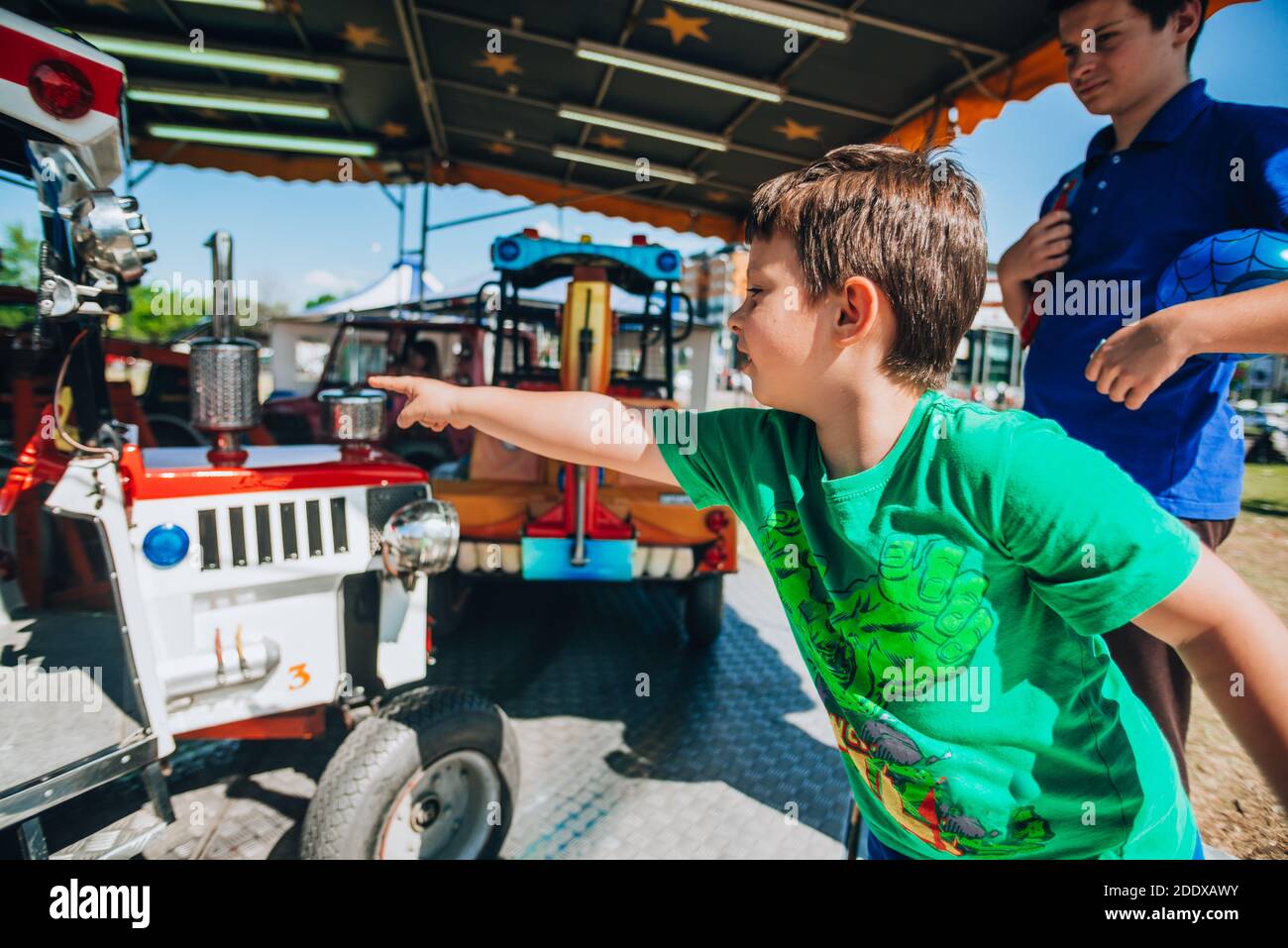 Beautiful boy having fun on the amusement rides at the local theme park ...