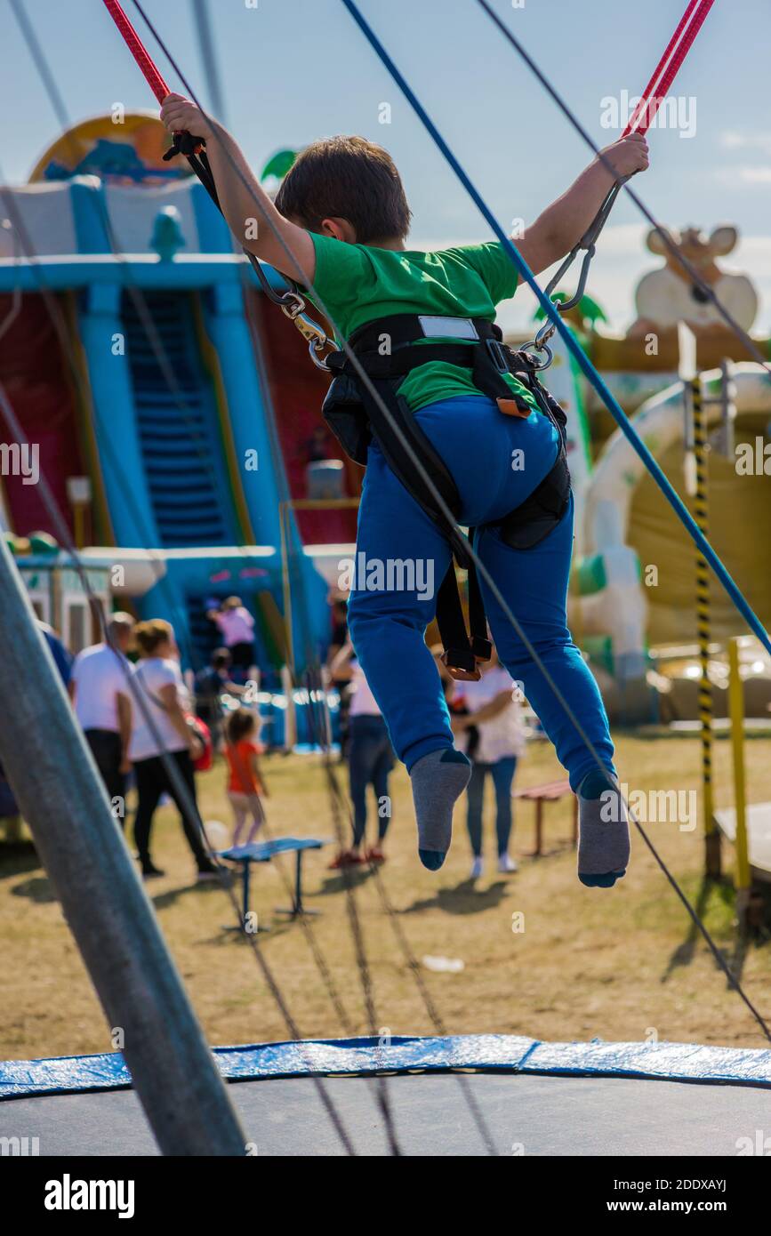 Cute joyful smiling boy playing on the big bungee trampoline Stock ...