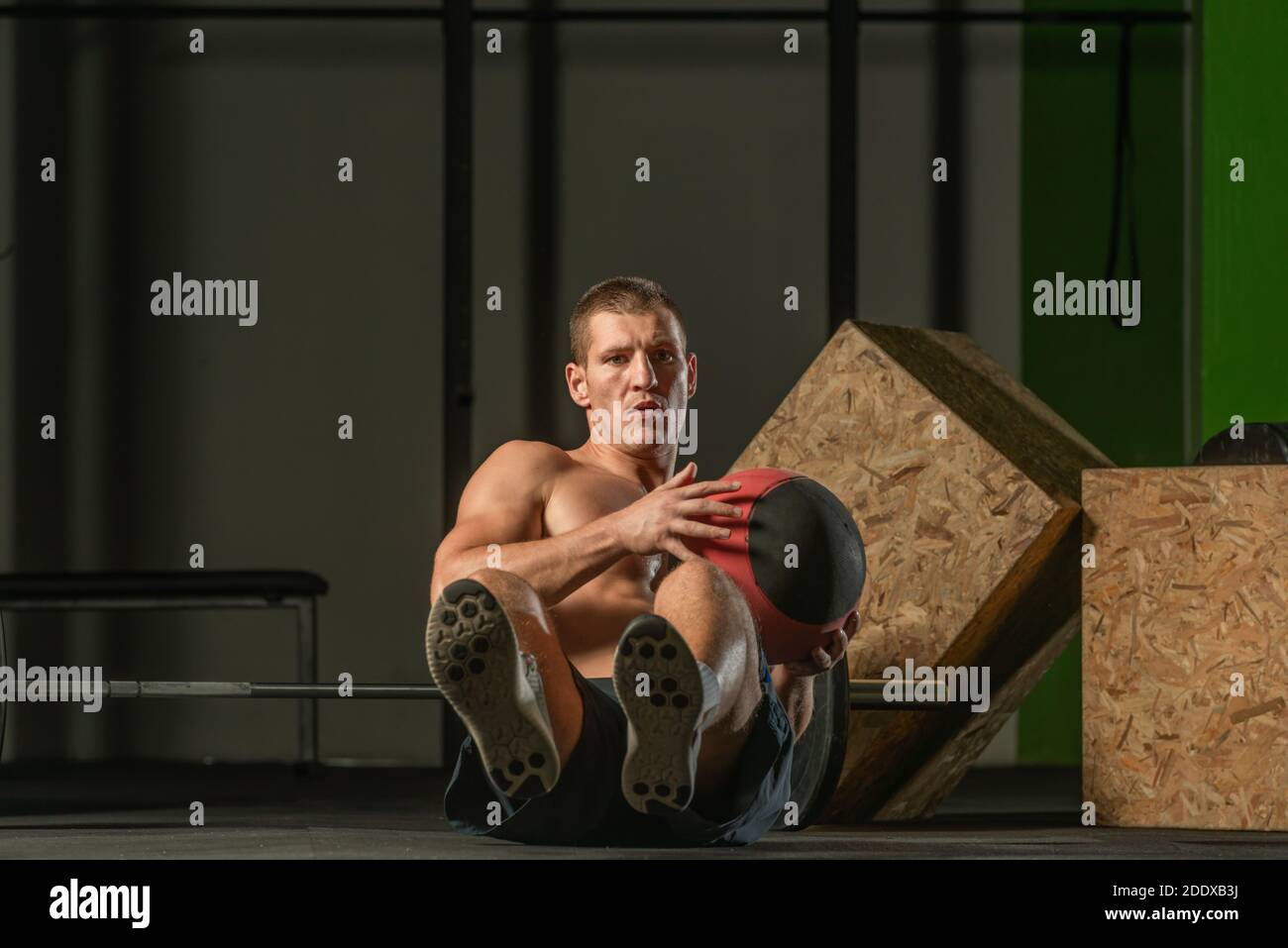 Close-up photo of a handsome bodybuilder working out seated using a ...