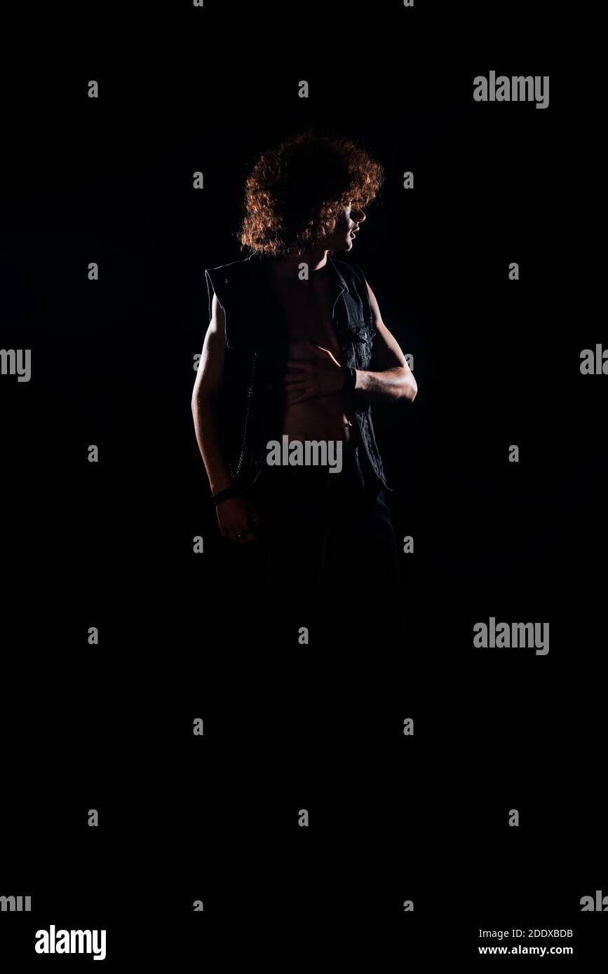 Body shot of an attractive male punk model posing isolated on black ...