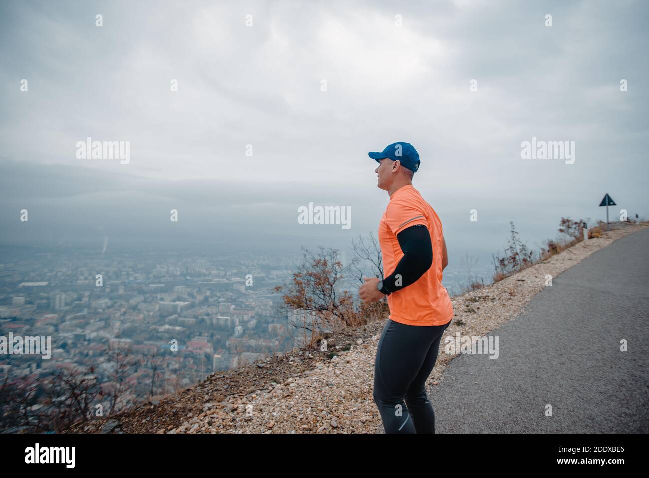 Older well built man in activewear stretching out his legs before ...
