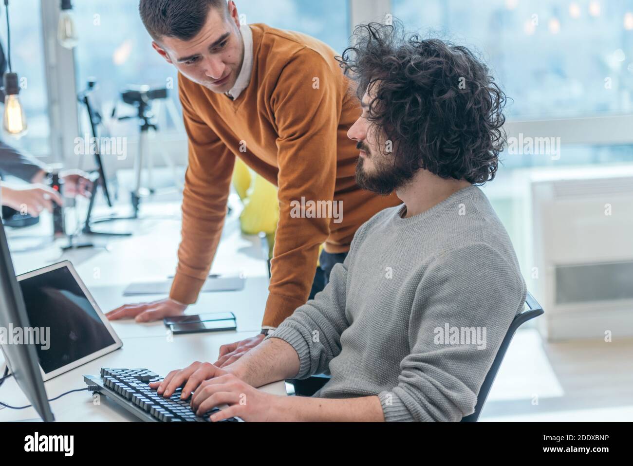 Portrait of two busy colleagues working on pc economy project on modern ...
