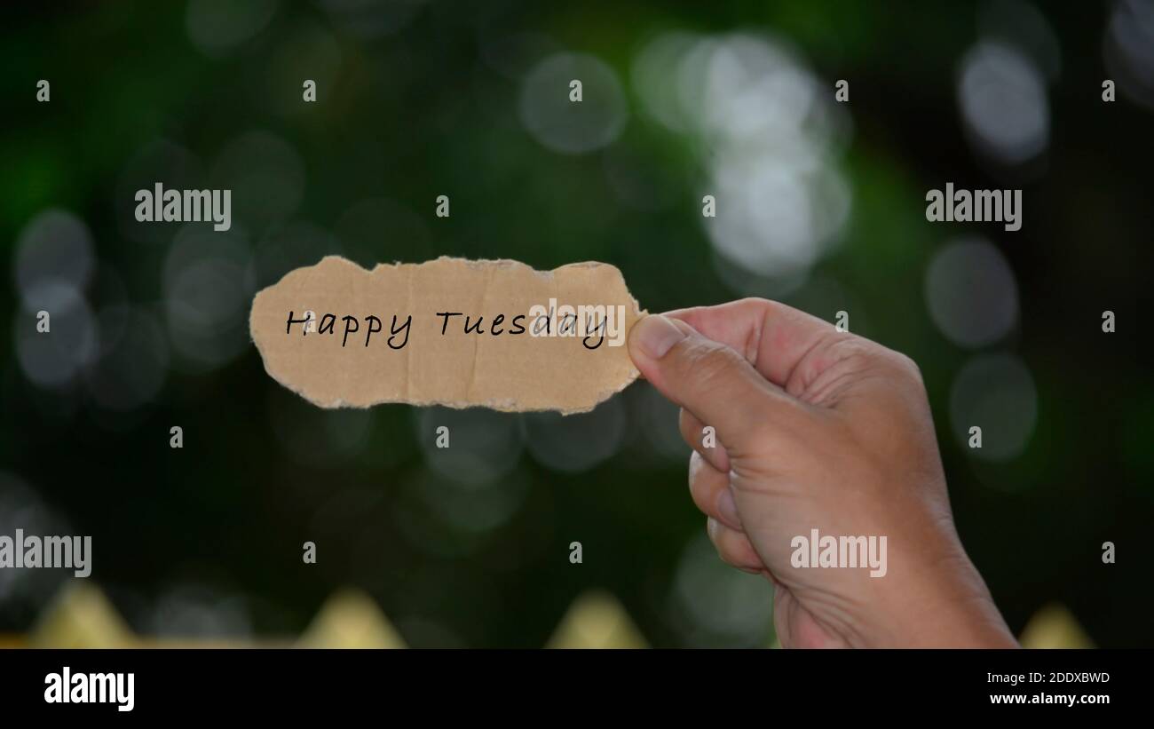 Happy Tuesday Text On Hands Holding Torn Paper With Blurred Dark ...