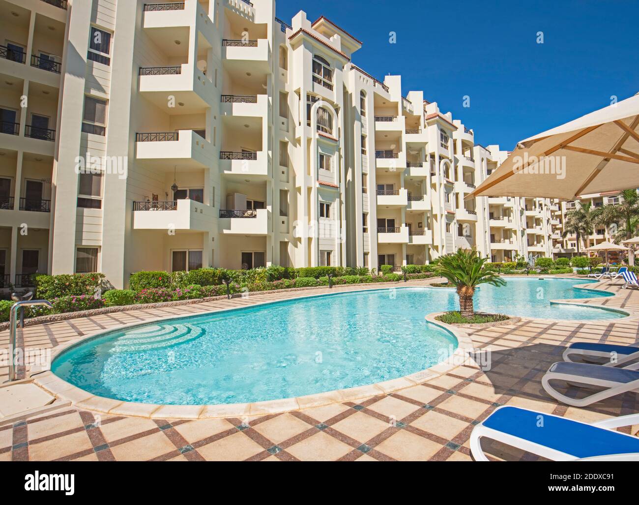 Large swimming pool with sun loungers at a luxury tropical hotel resort ...