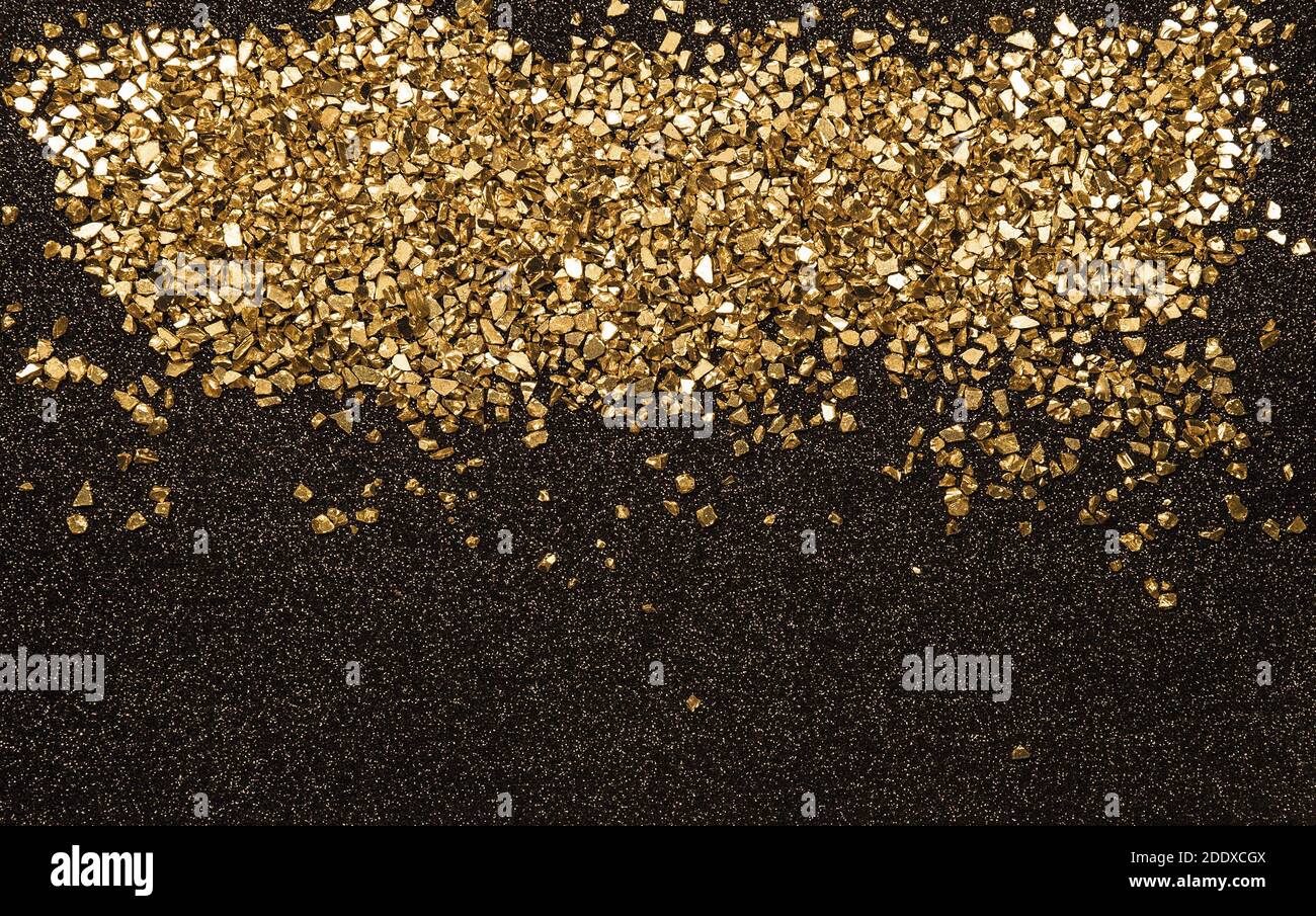 Golden glitter stones on black background Stock Photo - Alamy