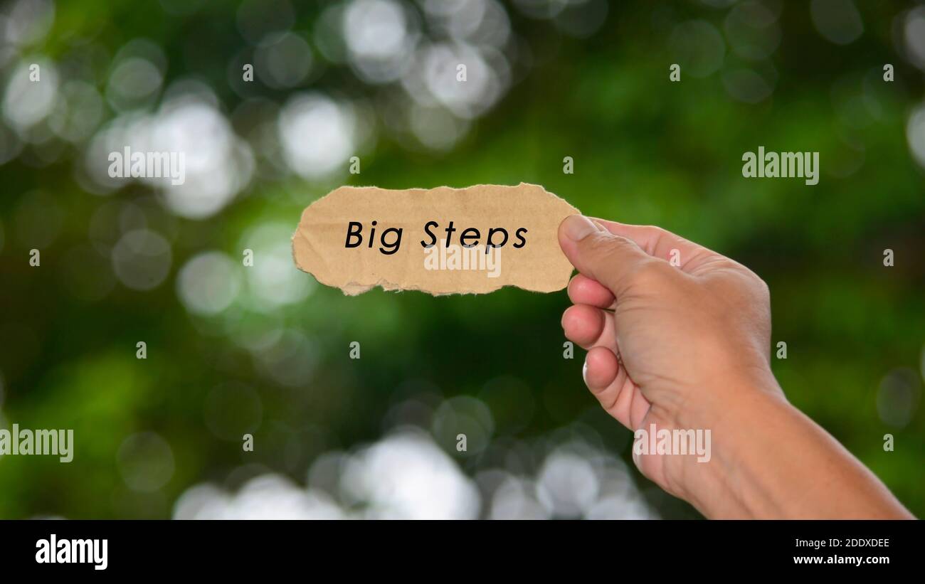 Big Steps Text On Hands Holding Torn Paper With Blurred Dark Background ...