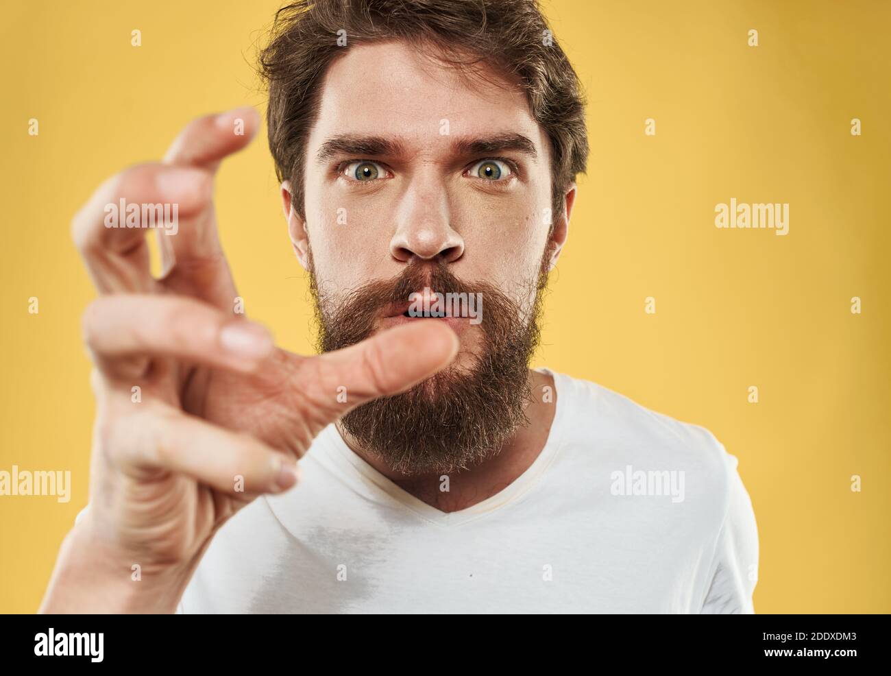 irritable young man with beard on yellow background cropped view Stock ...
