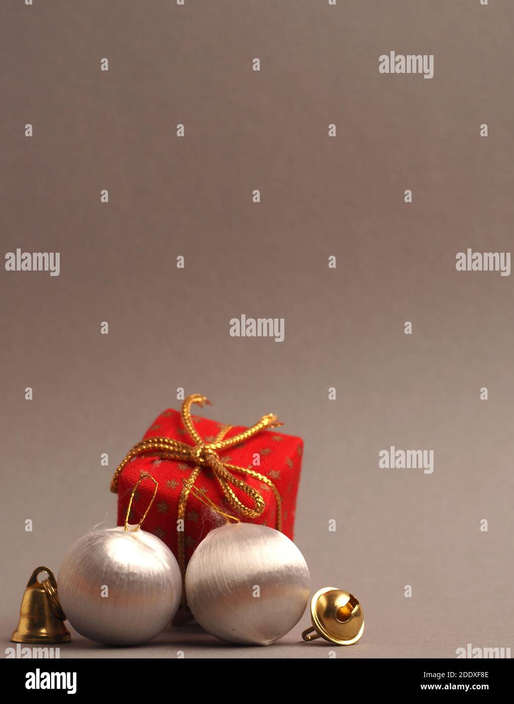 Silver vintage Christmas baubles with a red gift box on a grey ...