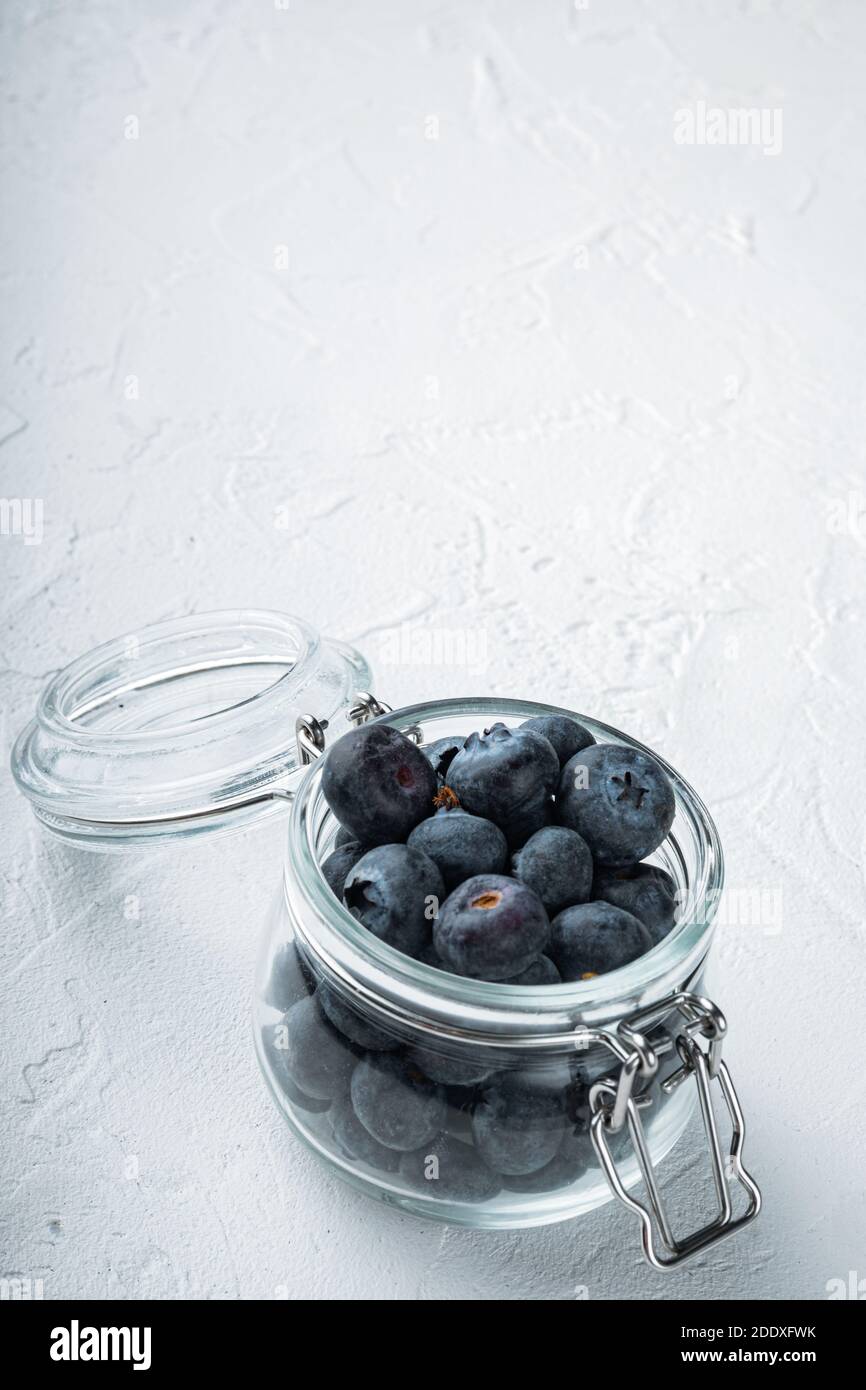 Ripe blueberry in glass jar with space for text, on white background ...