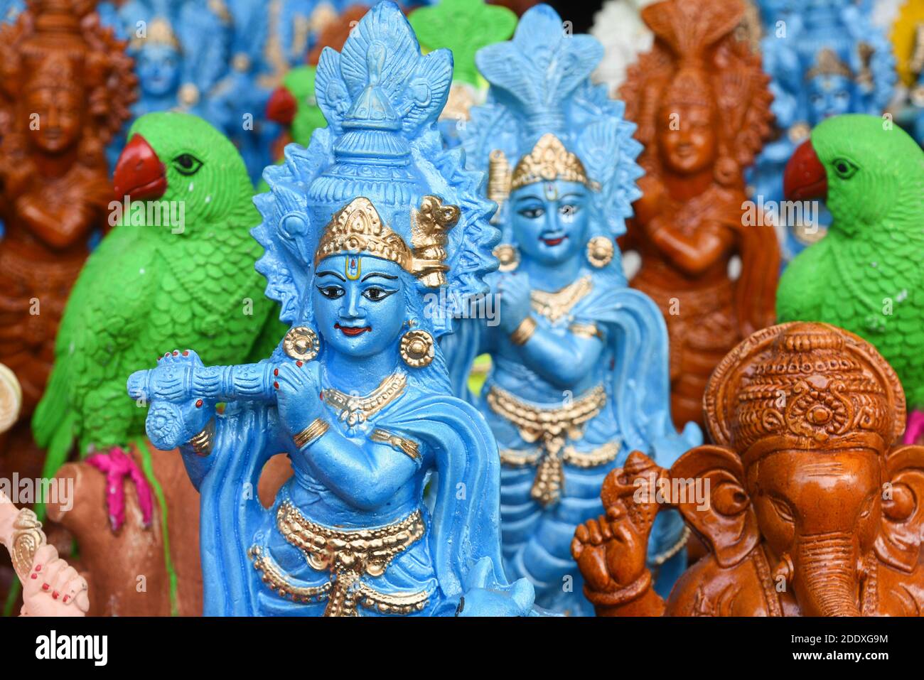 Many colorful statue sculptures of Hindu god, lord Krishna in an street ...