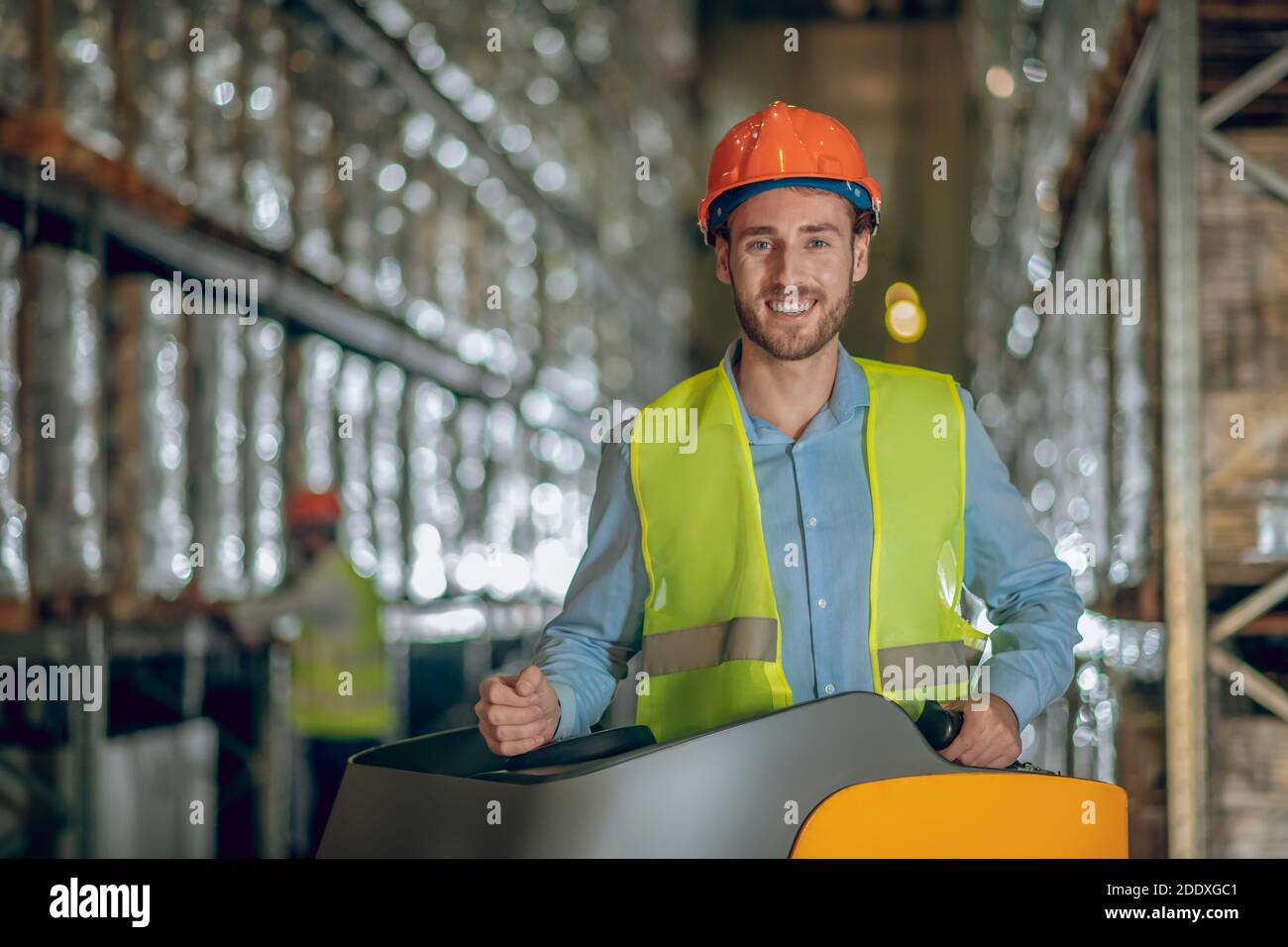 Warehouse worker in protective helmet smiling positively Stock Photo ...