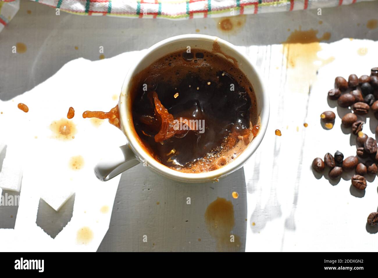 Sugar cube falling into a cup of coffee/A sugar cube dropped into a cup ...