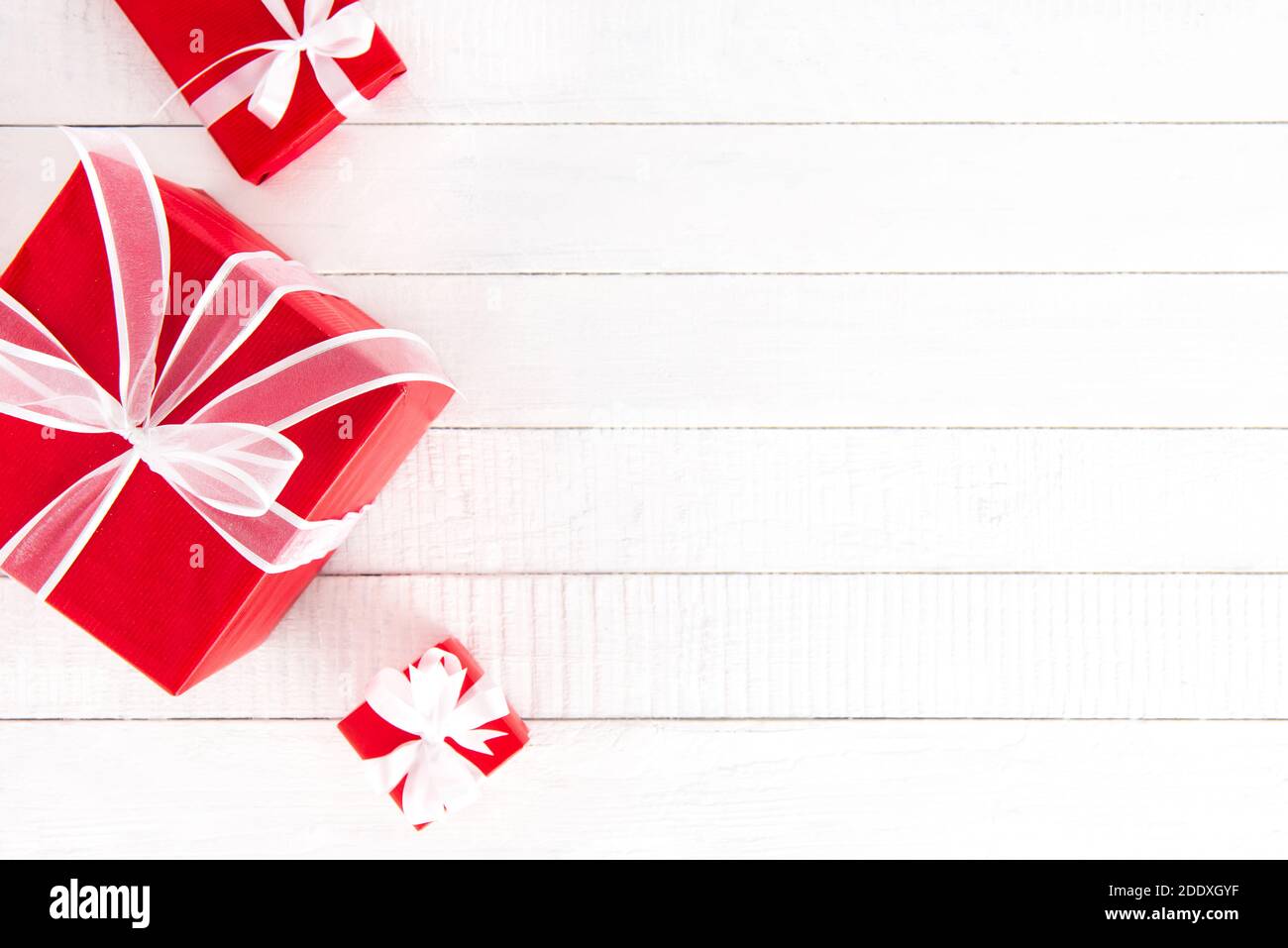 Red gift boxes on white wood background, top view, border design with ...