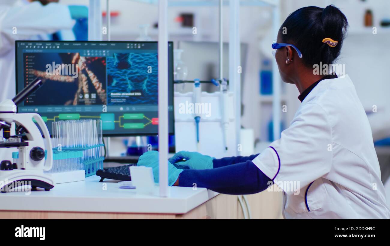 African woman biochemist researcher checking manifestations of vaccine ...