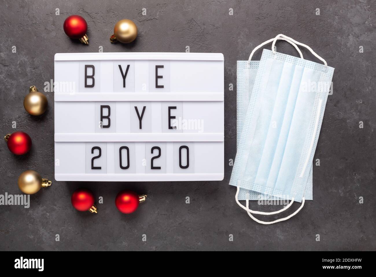 Lightbox with text BYE BYE 2020 with medical mask on dark background ...