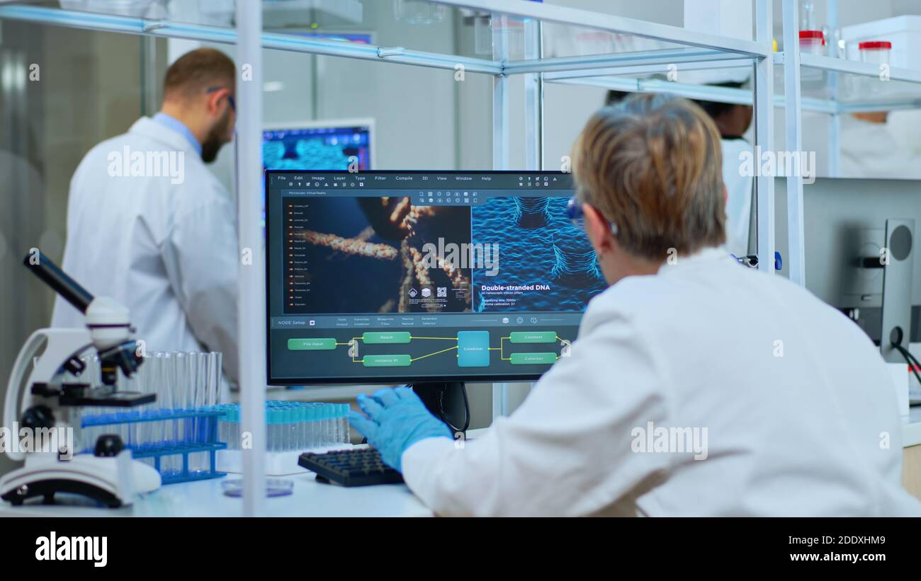 Medical research scientist typing codes on pc in biological applied ...