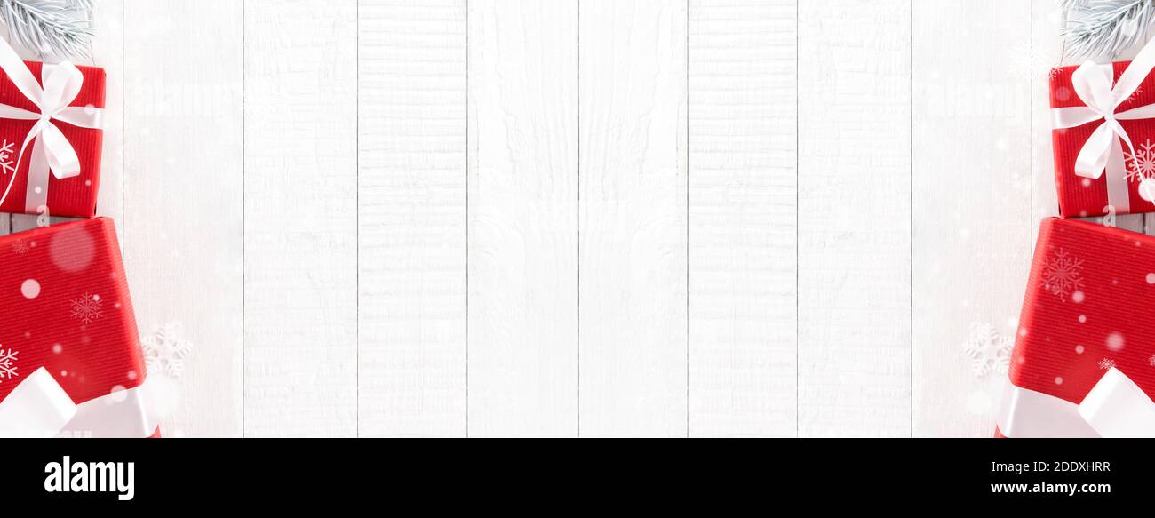 Red Christmas gift boxes with decorated items at border on white wood ...