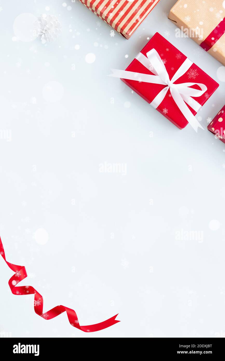 Christmas gift boxes and curled red ribbon on light blue vertical ...