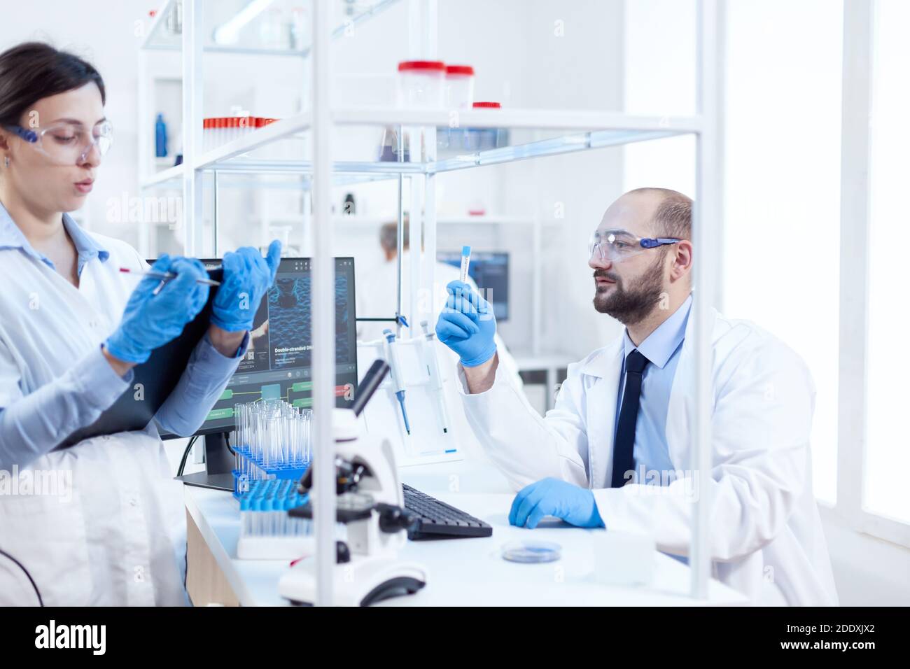 Young man scientist looking pensive at chemical solution in test tubes ...