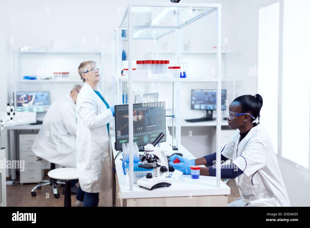 Scientist with african ethnicity holding sample recipient working with ...