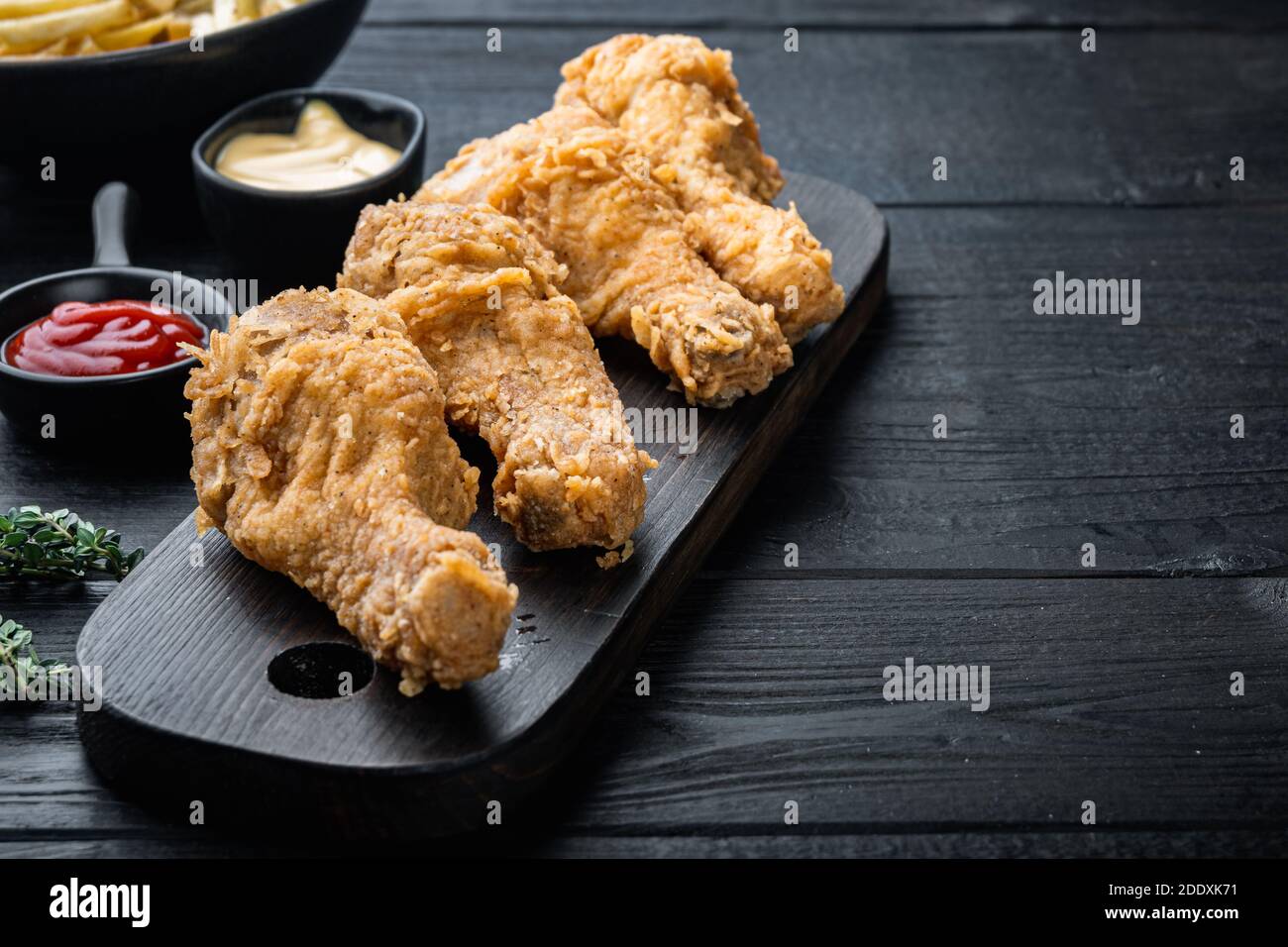 Chicken leg breaded and fried on black wooden table, with copy space ...