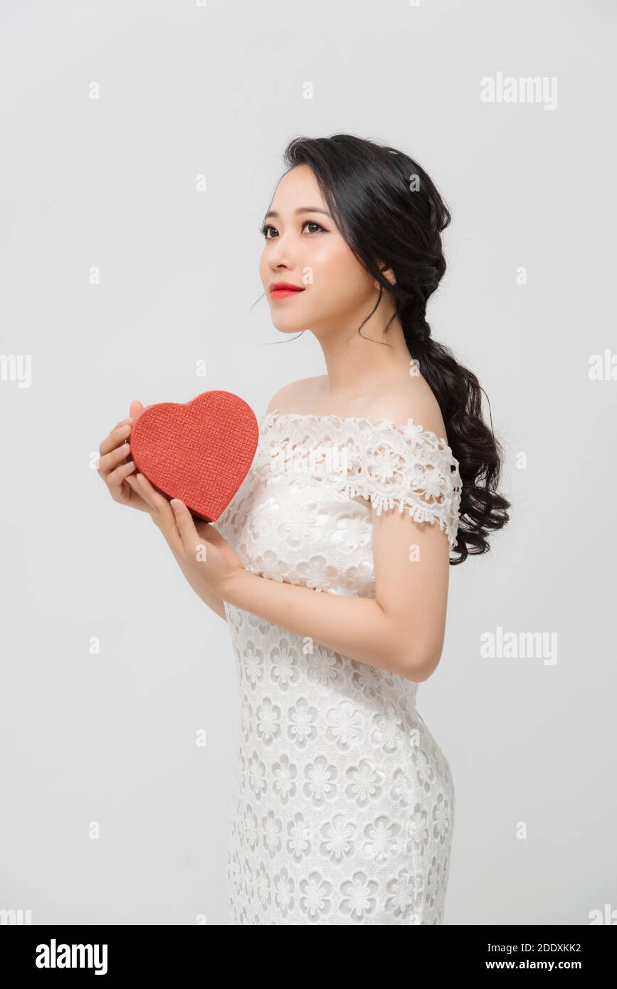 Beautiful girl holding love red gift box while standing isolated over ...