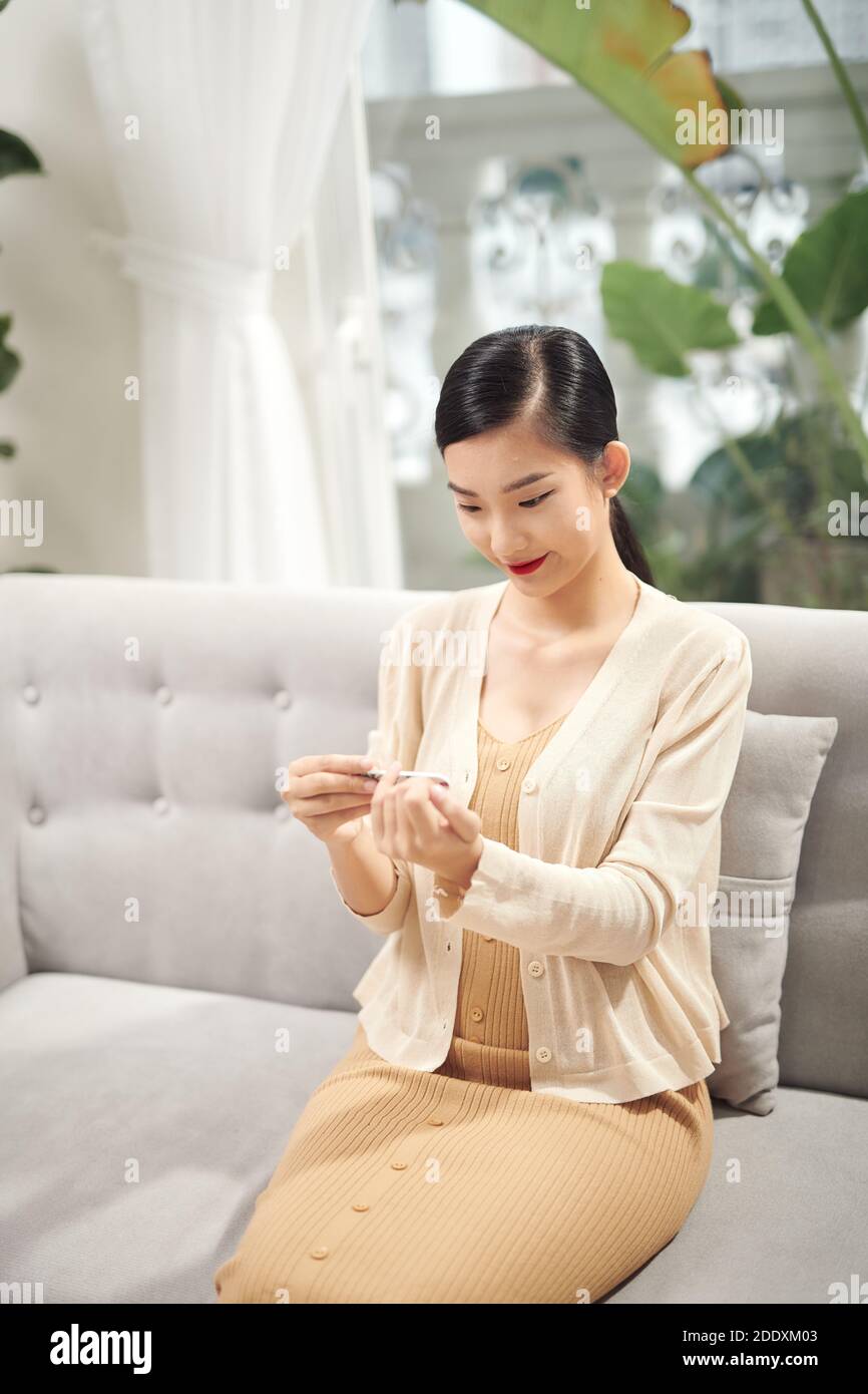 Young woman filing her nails, smiling Stock Photo - Alamy