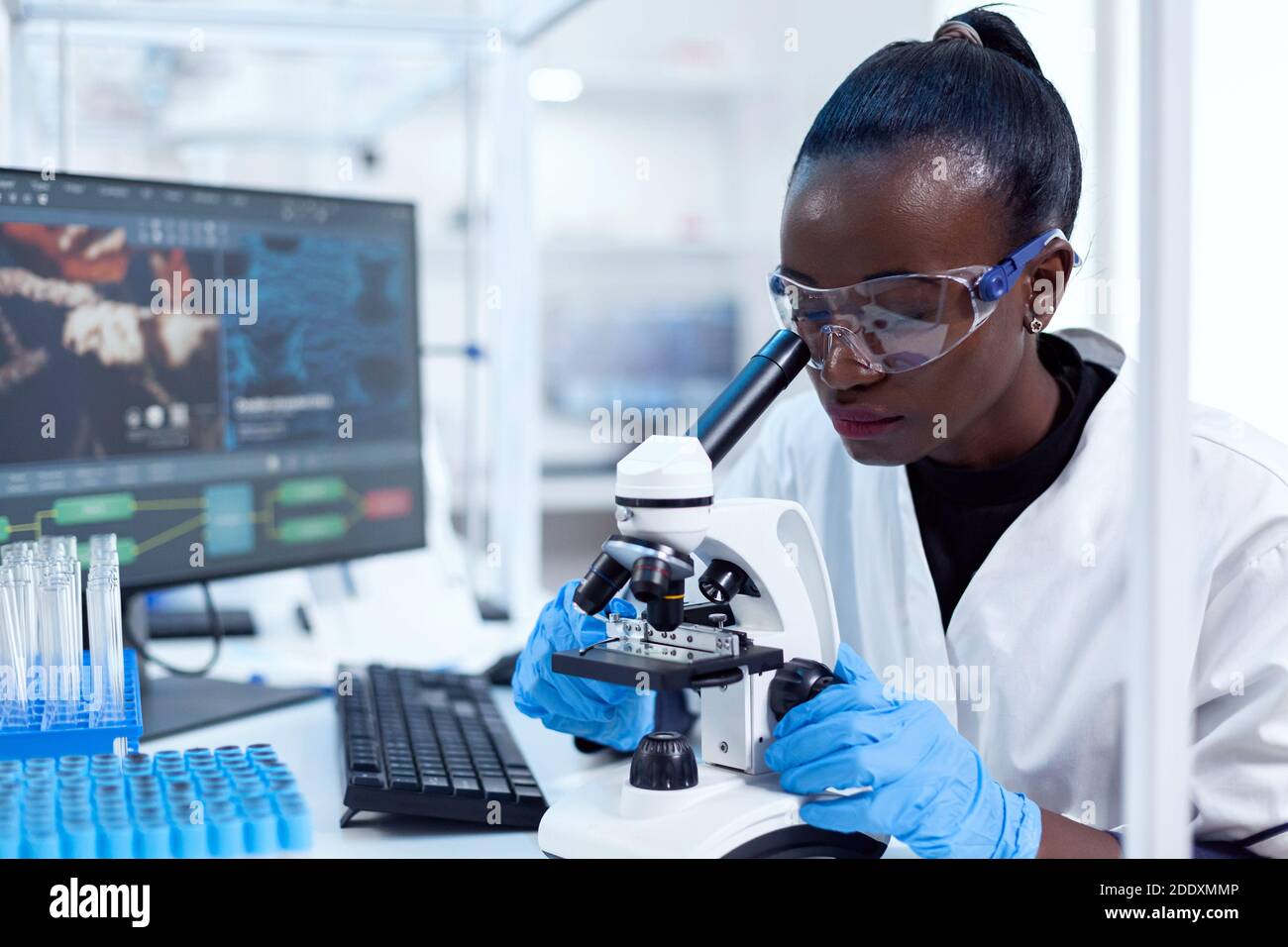 Medical researcher with african ethnicity using microscope doing ...