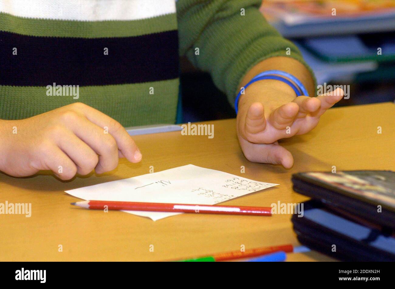 student in elementary school calculating with fingers and writing on a ...