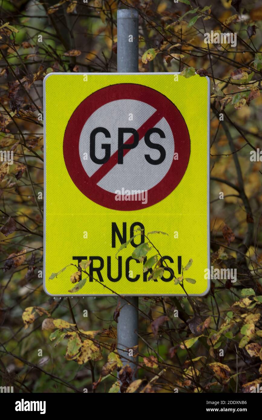 yellow No GPS reception and No Trucks traffic sign, autumn leaves in ...