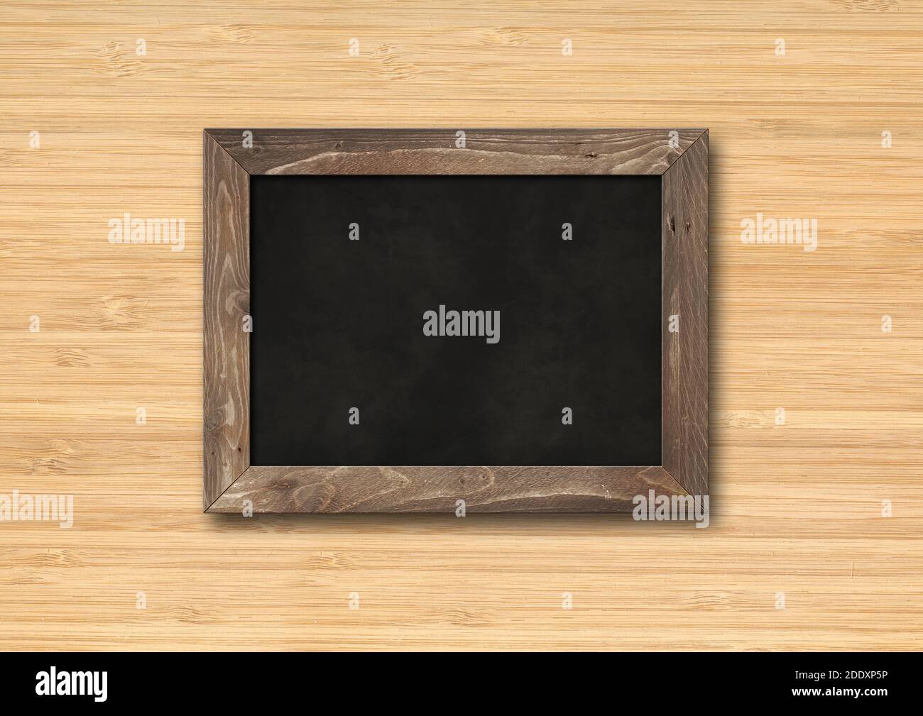 Old rustic black board isolated on a wooden background. Blank ...