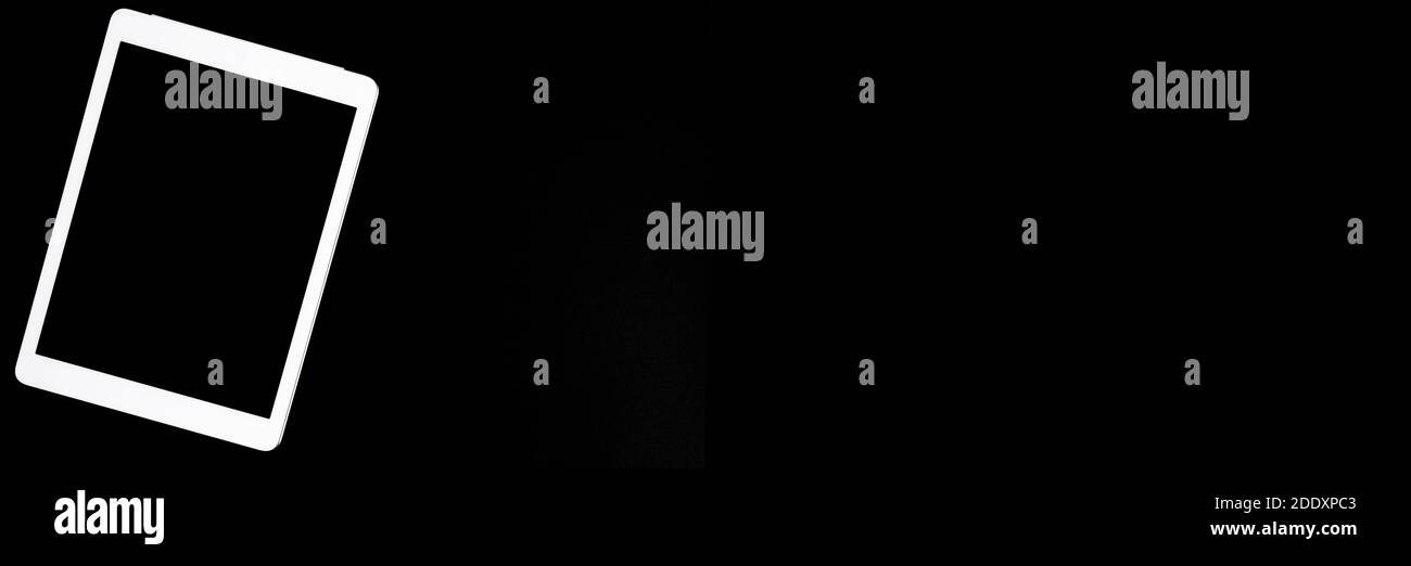 white tablet turned off on a black background. minimal black white ...