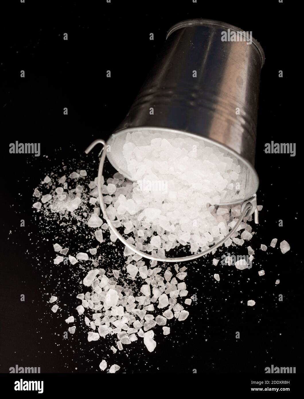 Salt with bucket on black background Stock Photo - Alamy