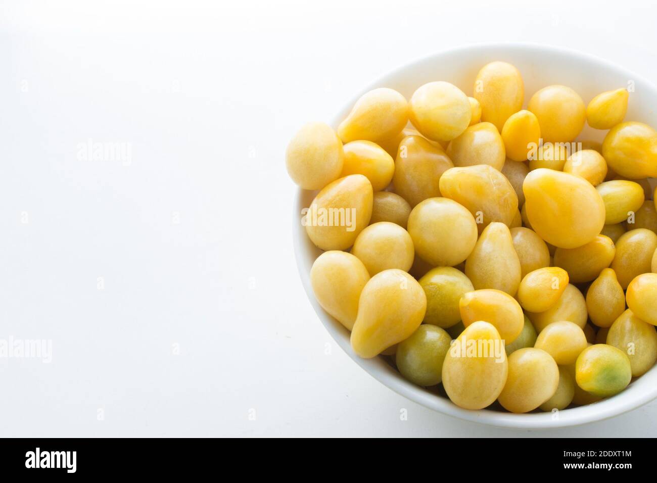 Small yellow pear isolated on white background, isis candy cherry ...