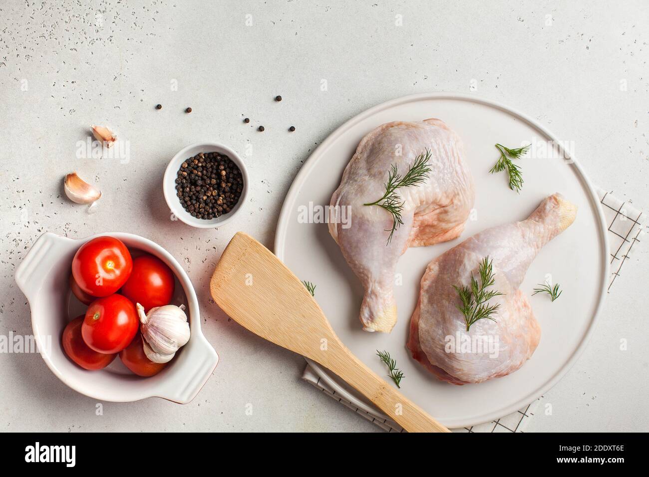 Farmed poultry. Chilled raw chicken legs on a plate with vegetables and ...