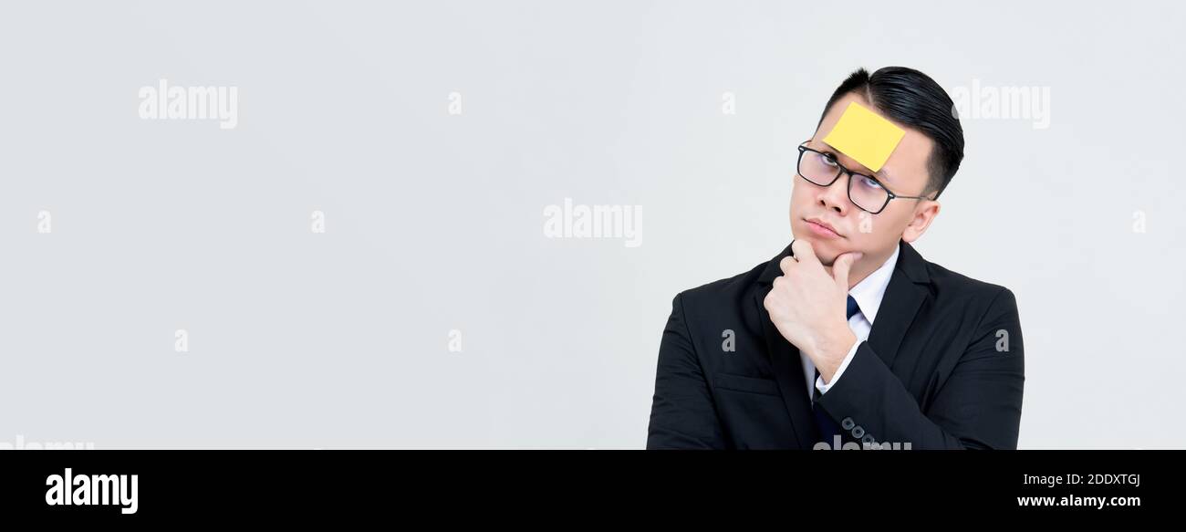 Bored and curious Asian businessman thinking with sticky note paper on ...