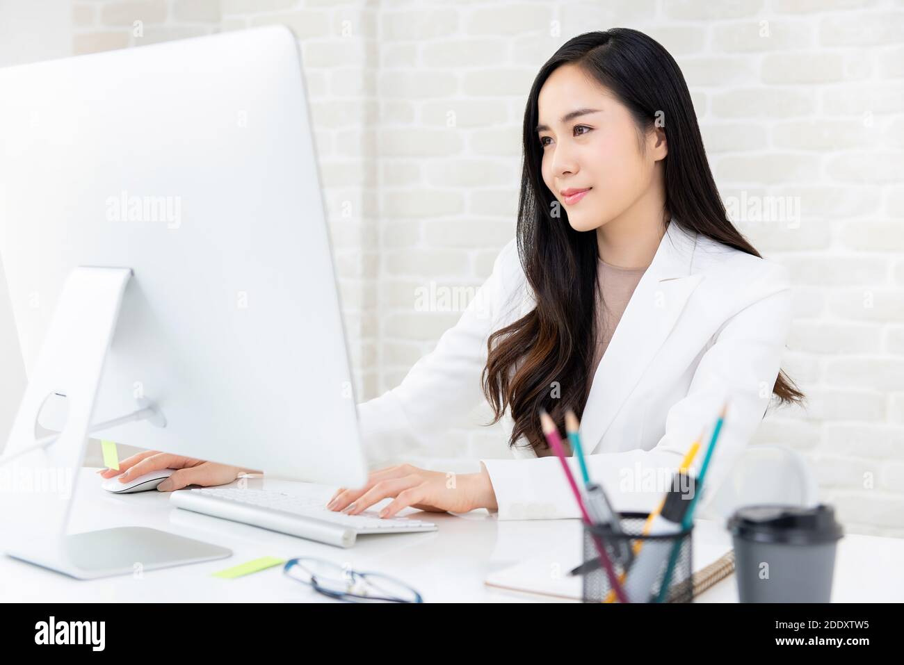 Young beautiful Asian working woman using computer searching ...