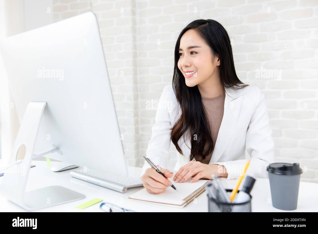 Beautiful smiling happy Asian working woman in white fomal suit looking ...