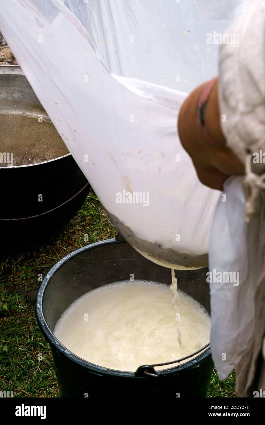 Homemade cheese production in a large cauldron over a fire Stock Photo ...