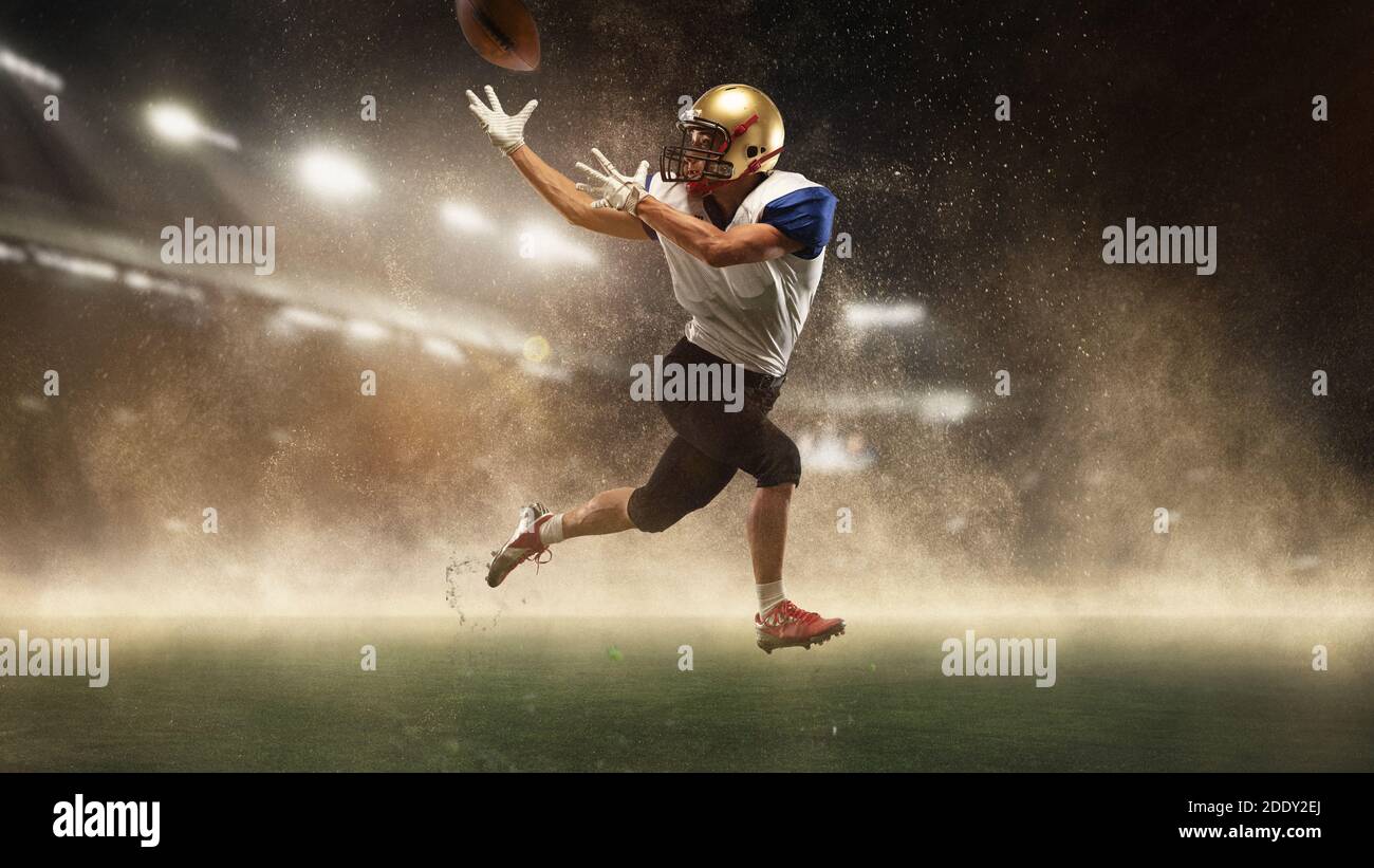 Hand-off. Young man american football player at stadium in motion on ...